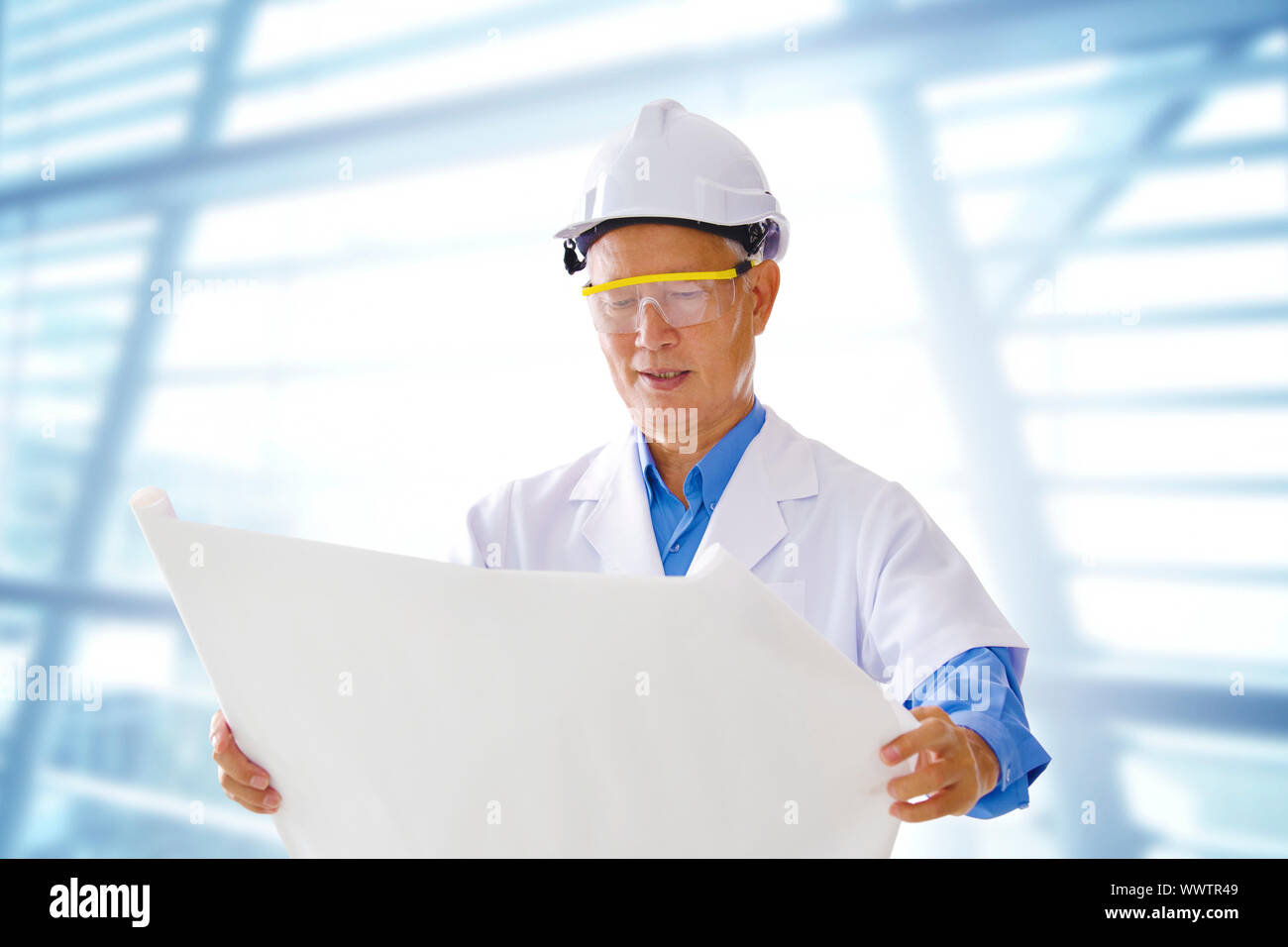 Senior Asian engineer with blueprints office background Stock Photo - Alamy