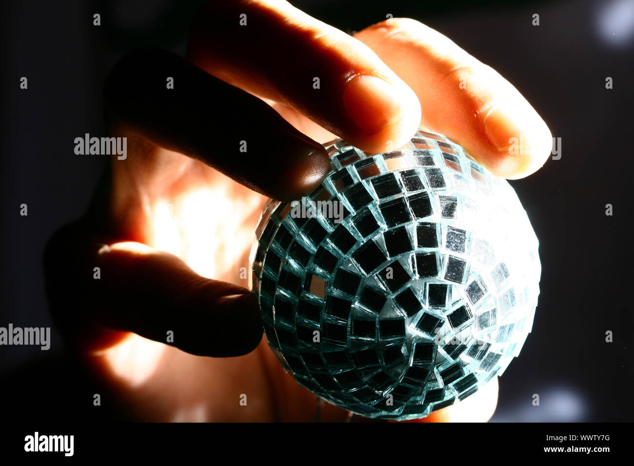 hand take a disco mirror ball in fingers Stock Photo - Alamy