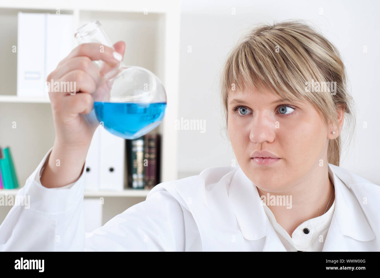 female chemist mixing liquids in test tubes, working in lab Stock Photo ...
