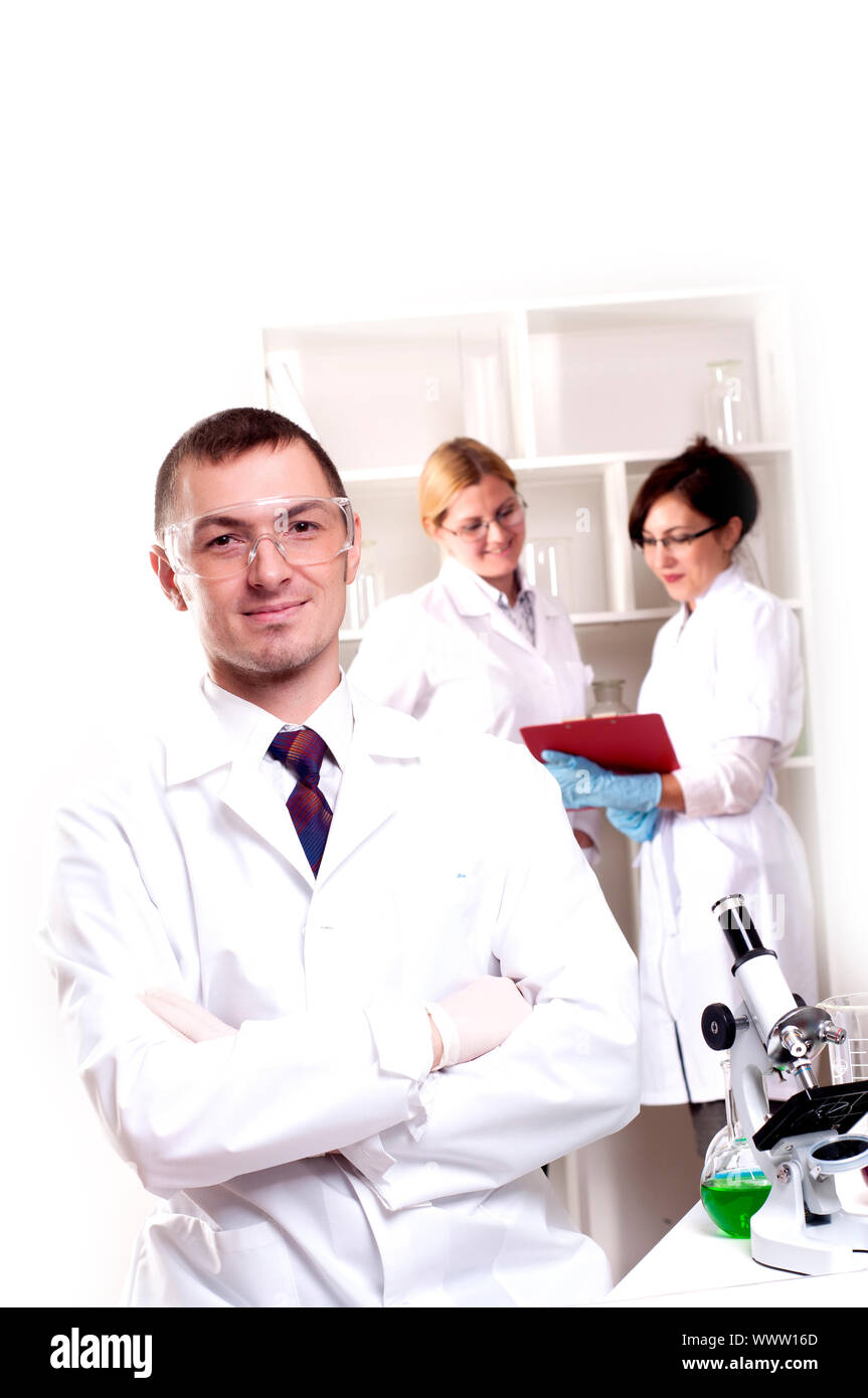 Three doctors are smiling at the camera in a doctors' office ...