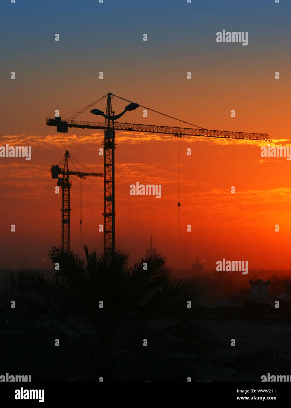 Construction crane over orange sunset sky Stock Photo - Alamy