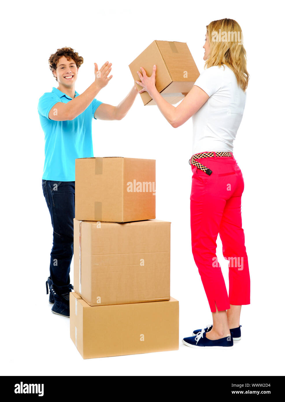 Woman passing cardboard cartons to man while he stacks them Stock Photo ...