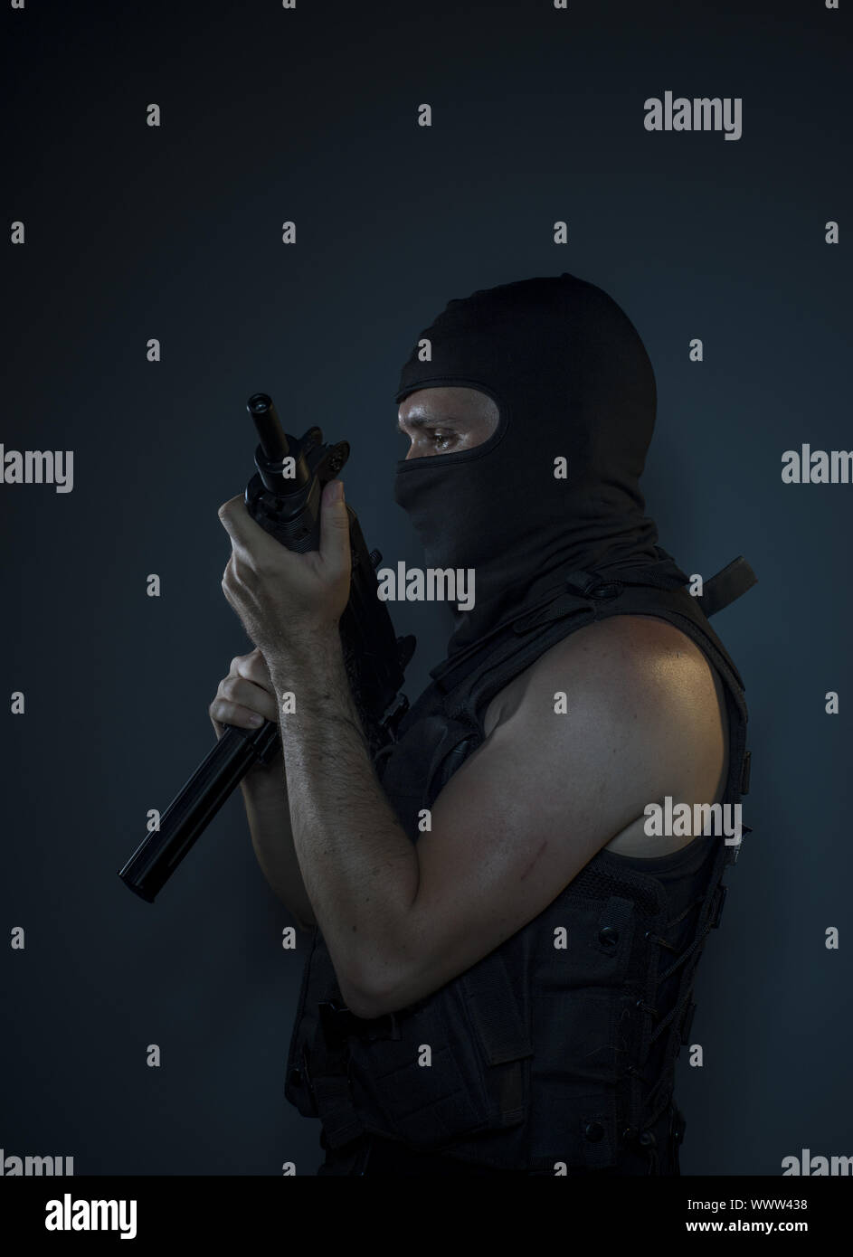 Terrorist, a man dressed in a bulletproof vest and balaclava, is armed ...