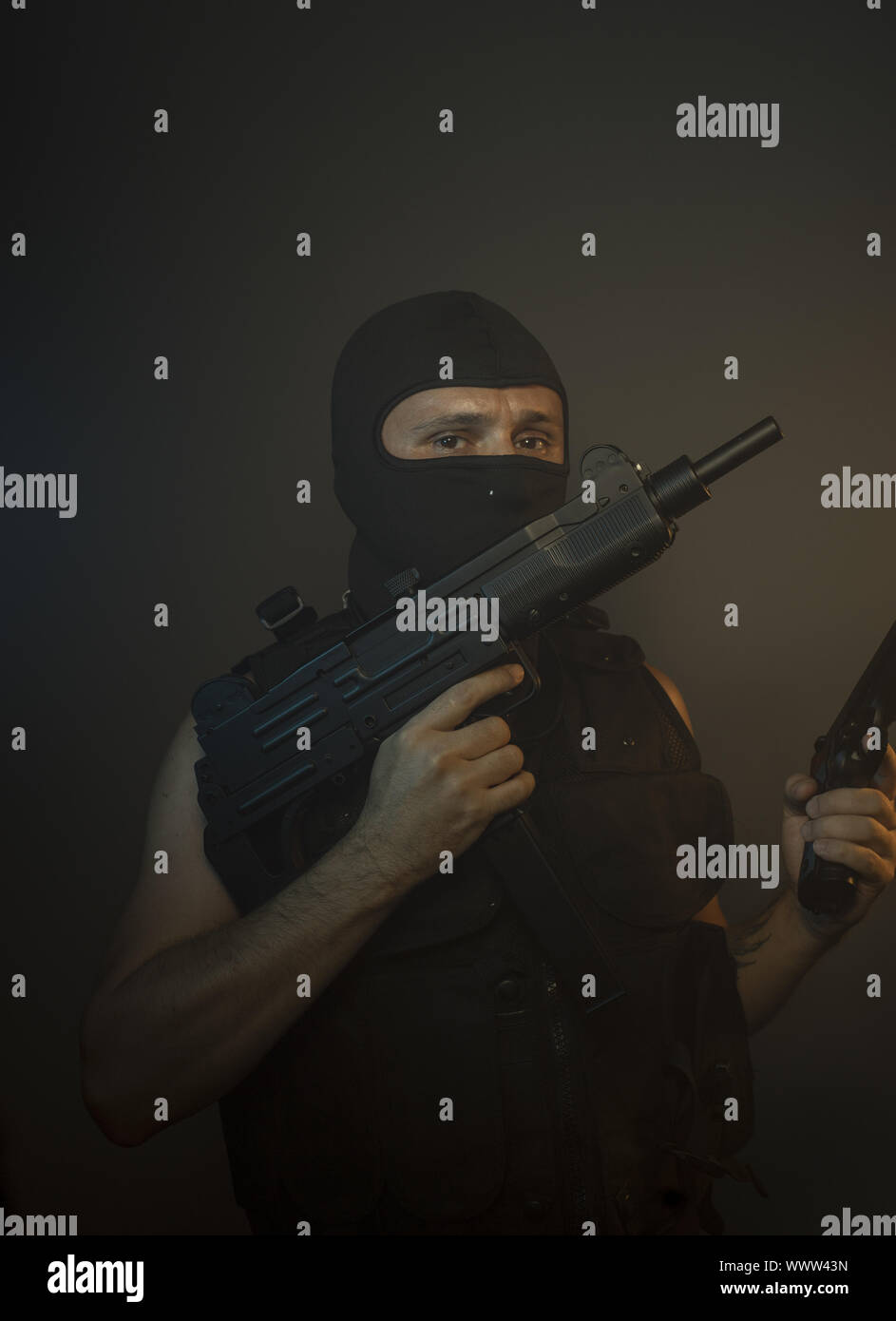 Terrorist, a man dressed in a bulletproof vest and balaclava, is armed ...