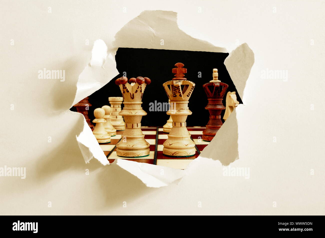 chess pieces behind hole in blank paper Stock Photo - Alamy