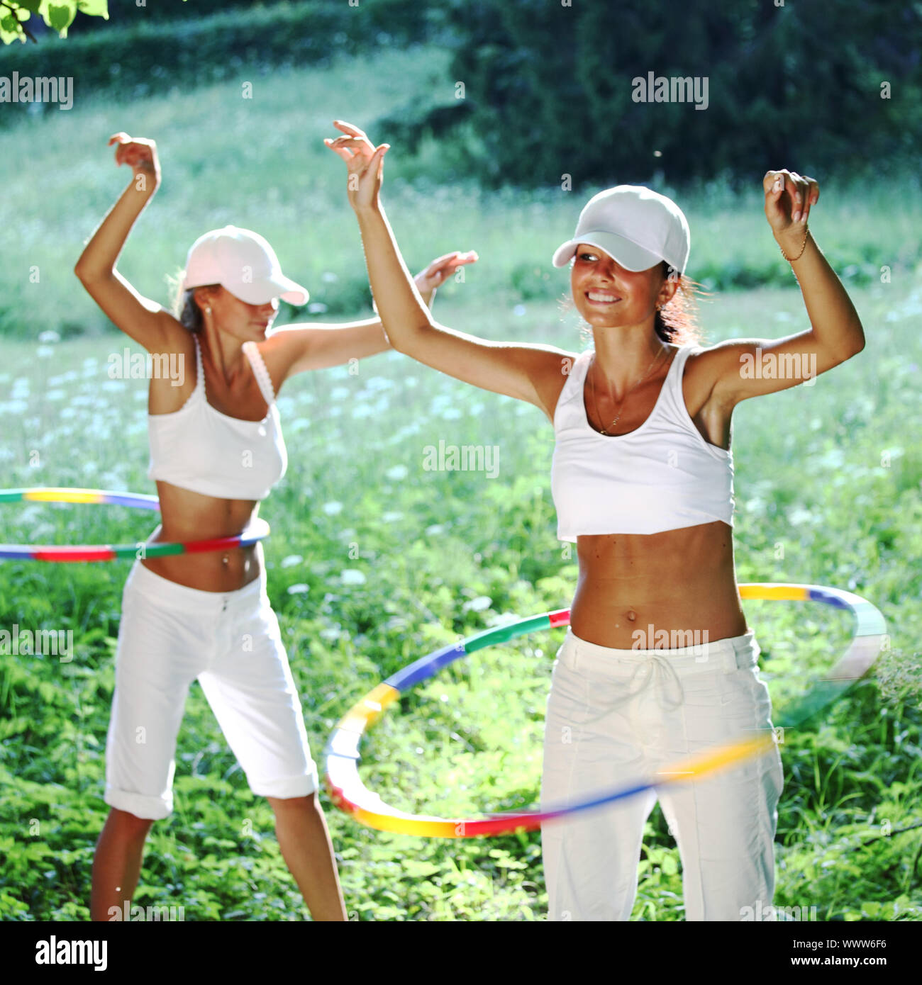 woman rotates hula hoop on nature background Stock Photo - Alamy