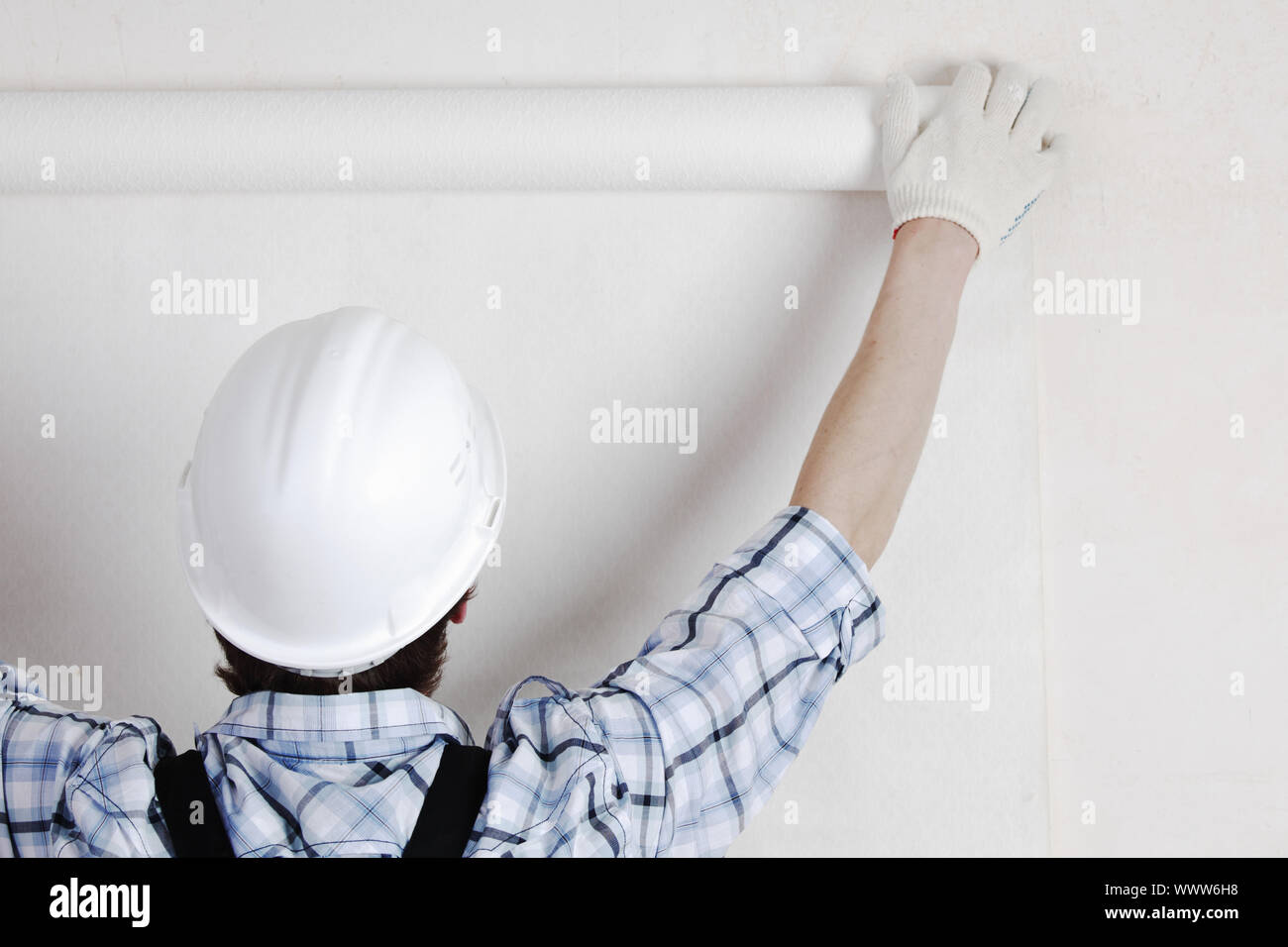 worker attaching wallpaper to wall Stock Photo - Alamy