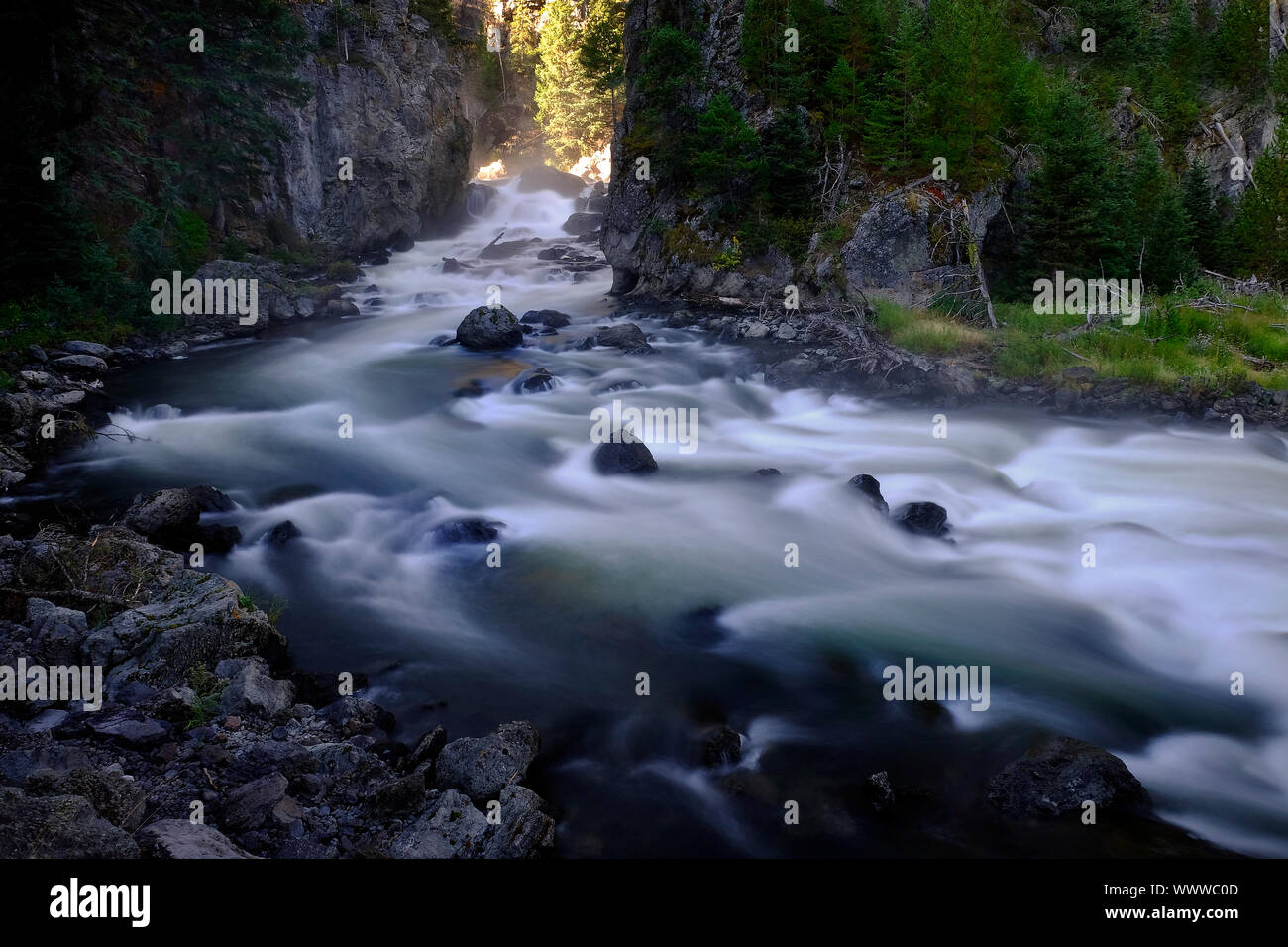 River in mountains wilderness running swiftly cascading down rocks in ...