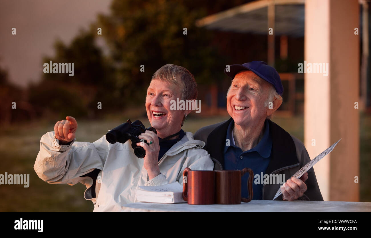 Happy elderly bird watchers outside in jackets Stock Photo - Alamy