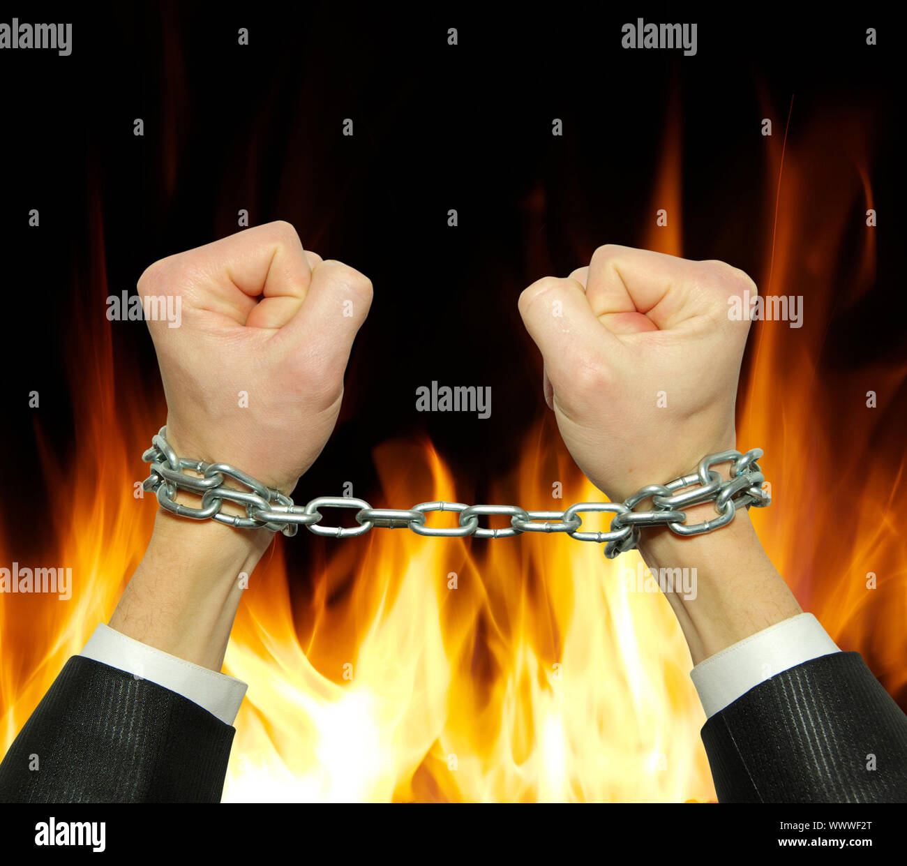 Hands in chains on a fire background Stock Photo - Alamy