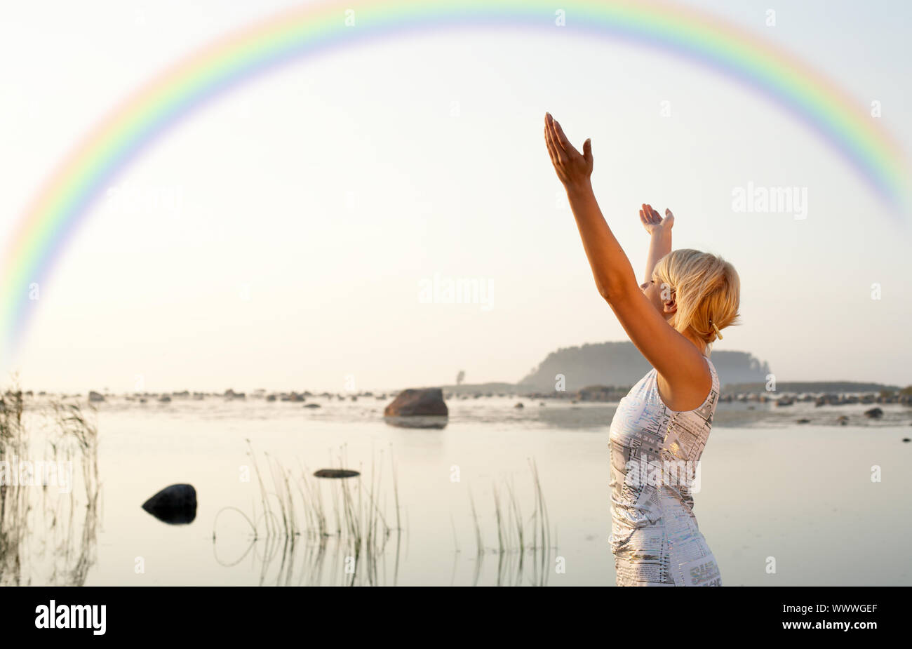 picture of pretty blond raising hands to the rainbow Stock Photo - Alamy