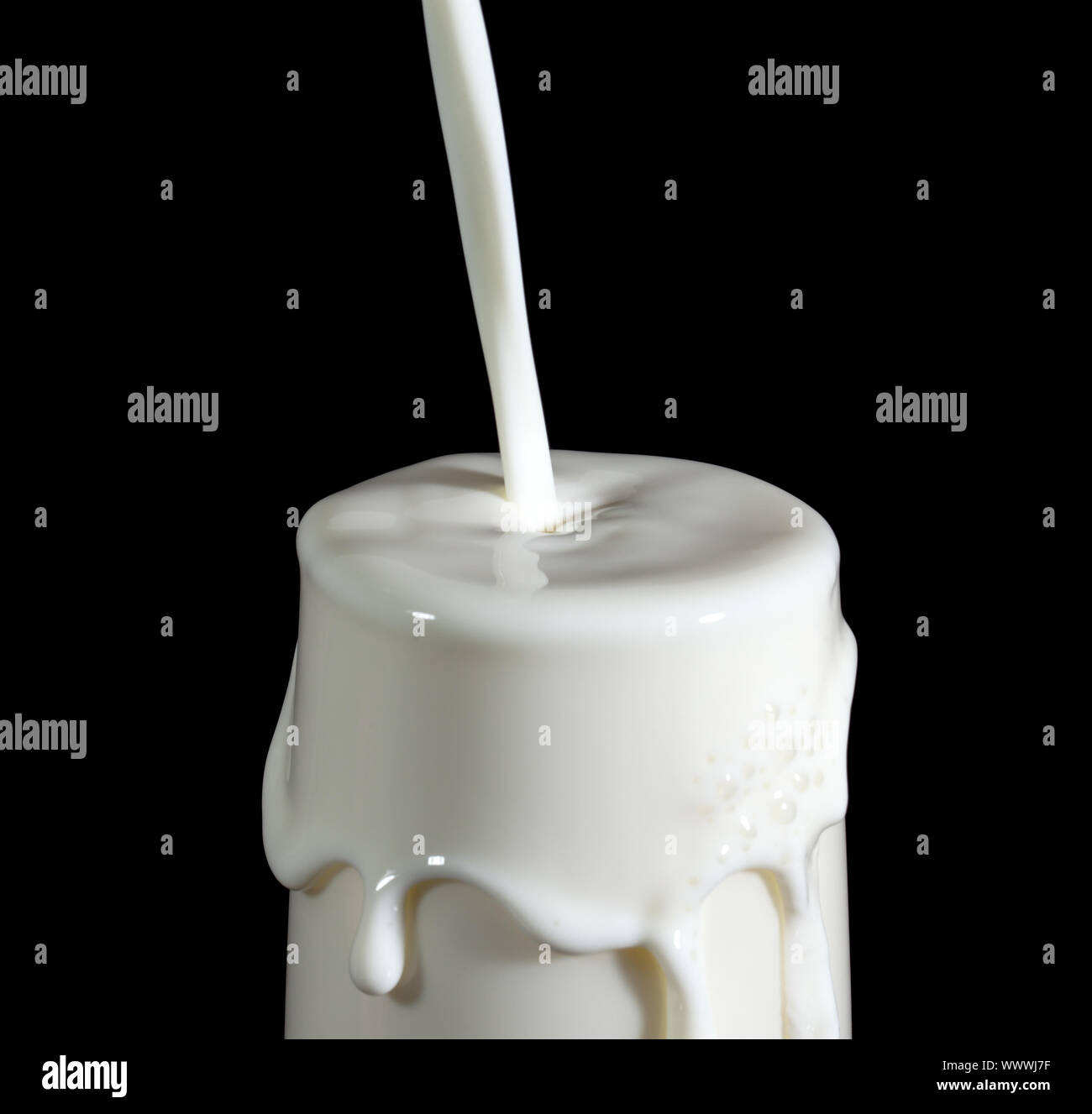 Pouring Milk in Glass, on black background Stock Photo - Alamy