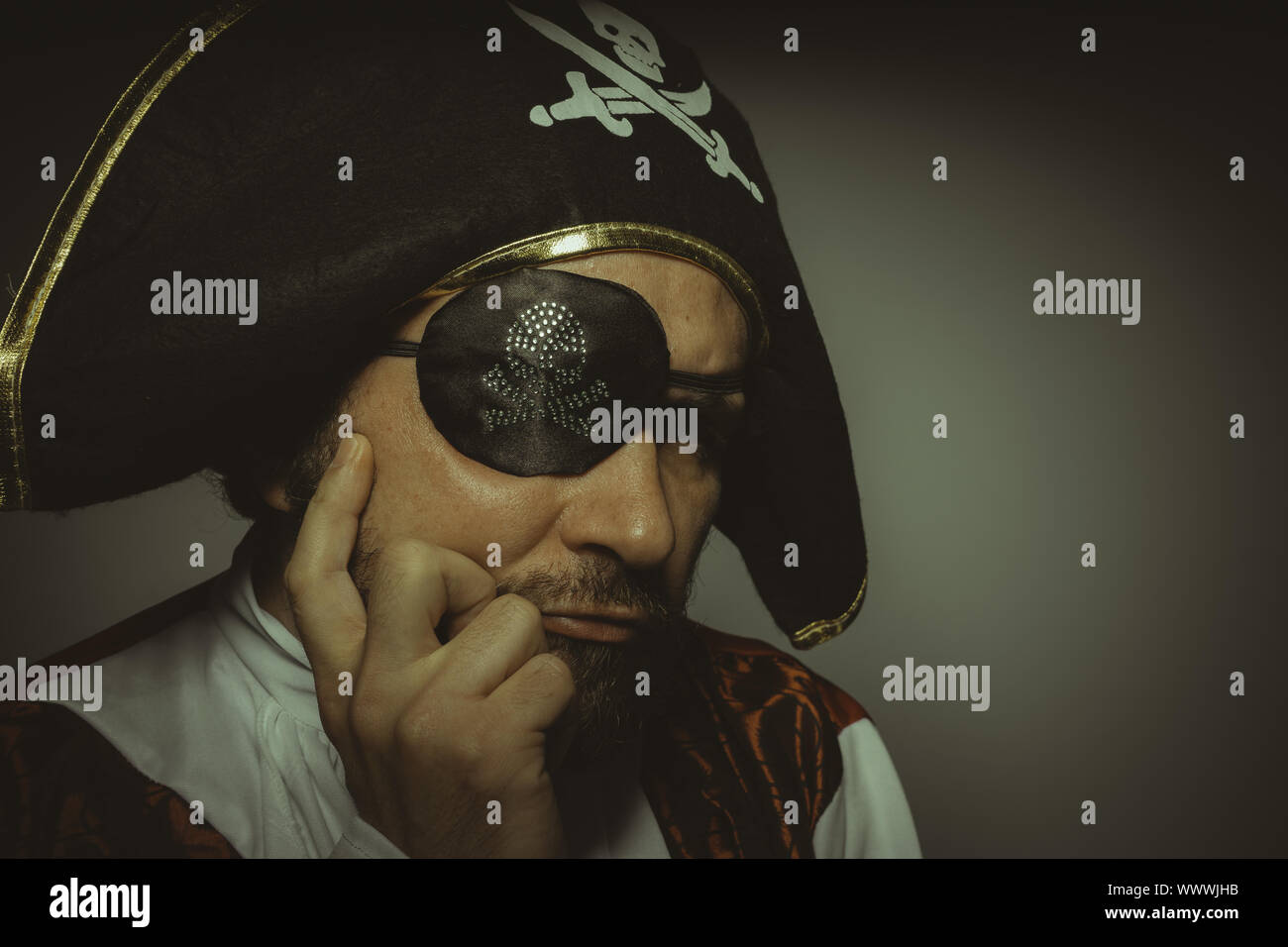 Man with beard dressed like a pirate, with eye patch and steel sword ...