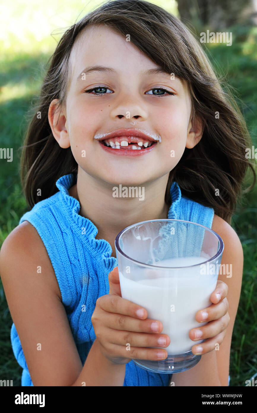 Little girl drinking milk with a milk mustache. Shallow depth of field ...