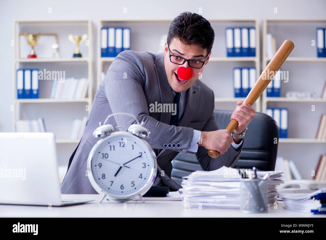 Clown businessman in the office with baseball bat and an alarm c Stock ...