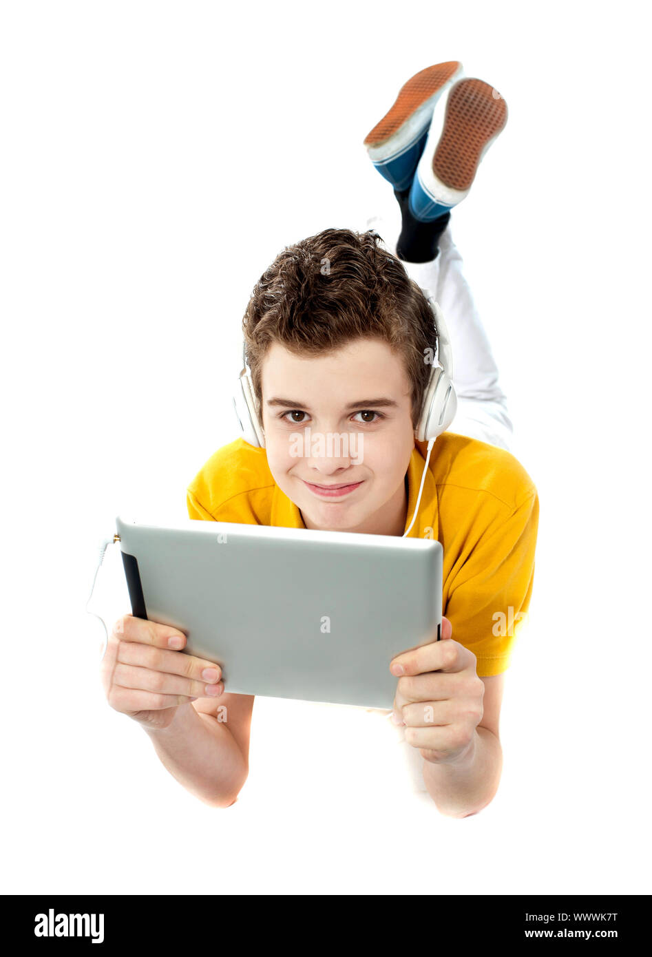 Smiling boy using a tablet computer while lying on floor Stock Photo ...