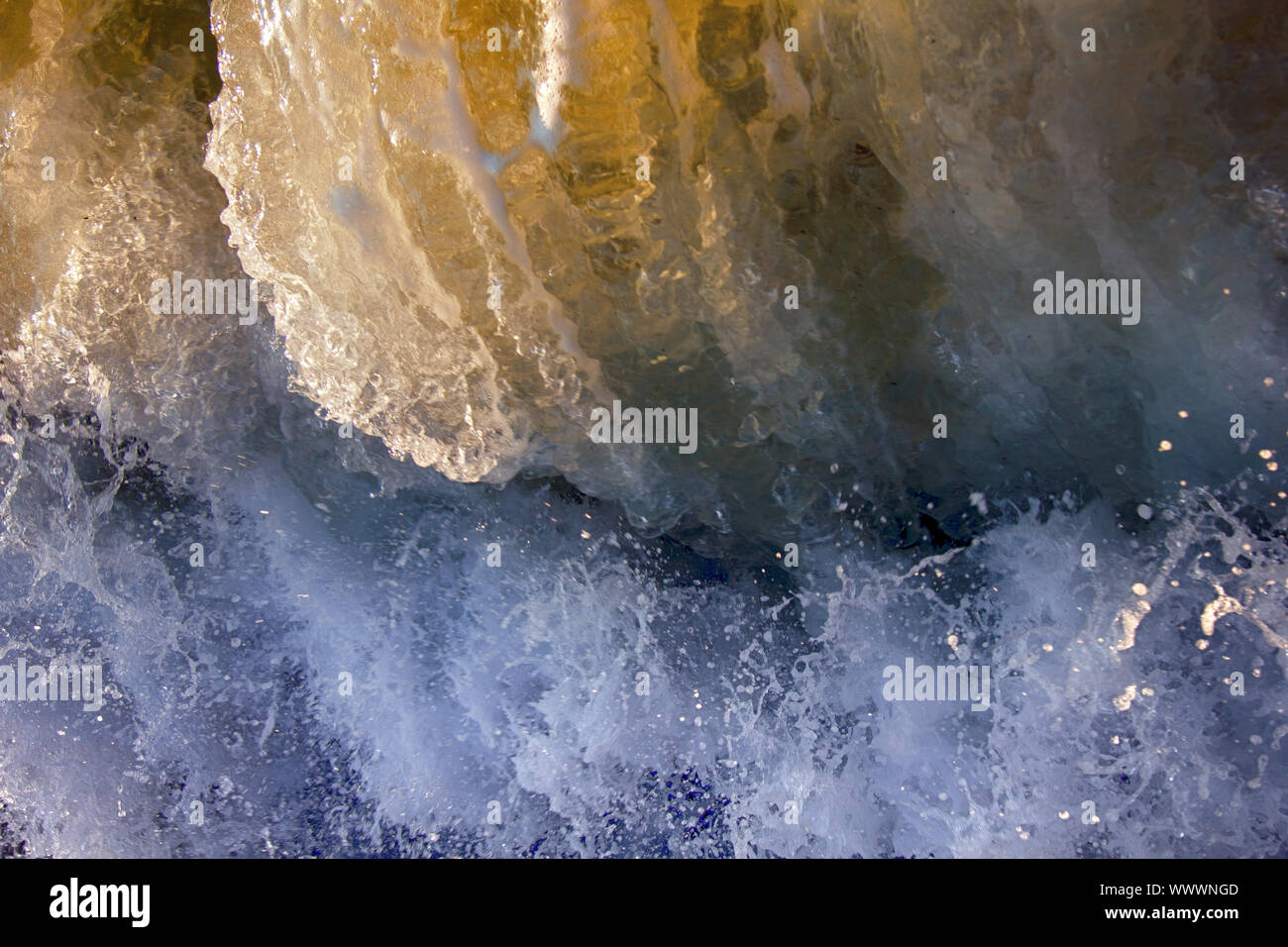 Sea rolling and receding water in rays of setting sun Stock Photo - Alamy
