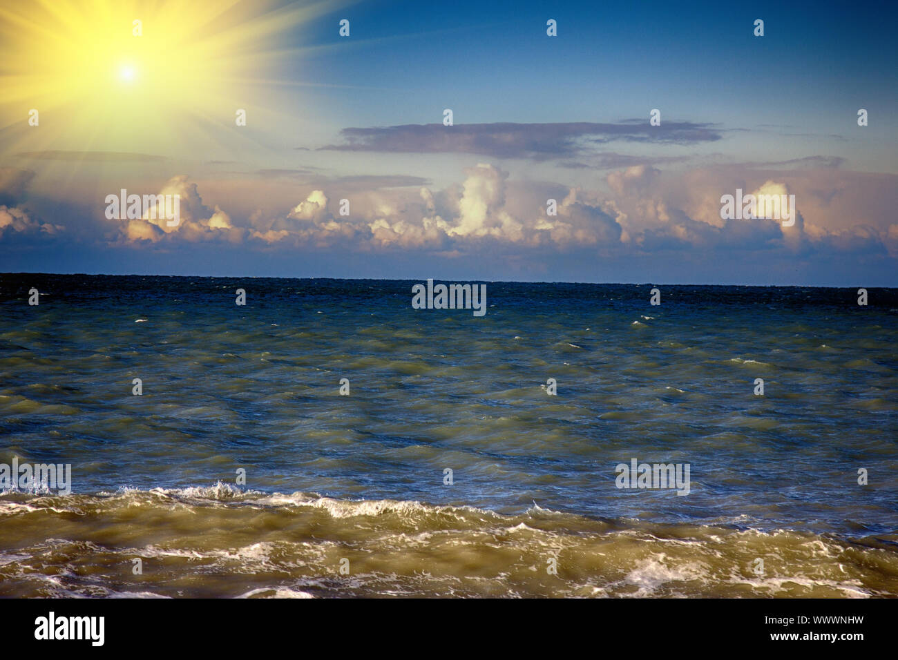 Sea rolling and receding water in rays of setting sun Stock Photo - Alamy