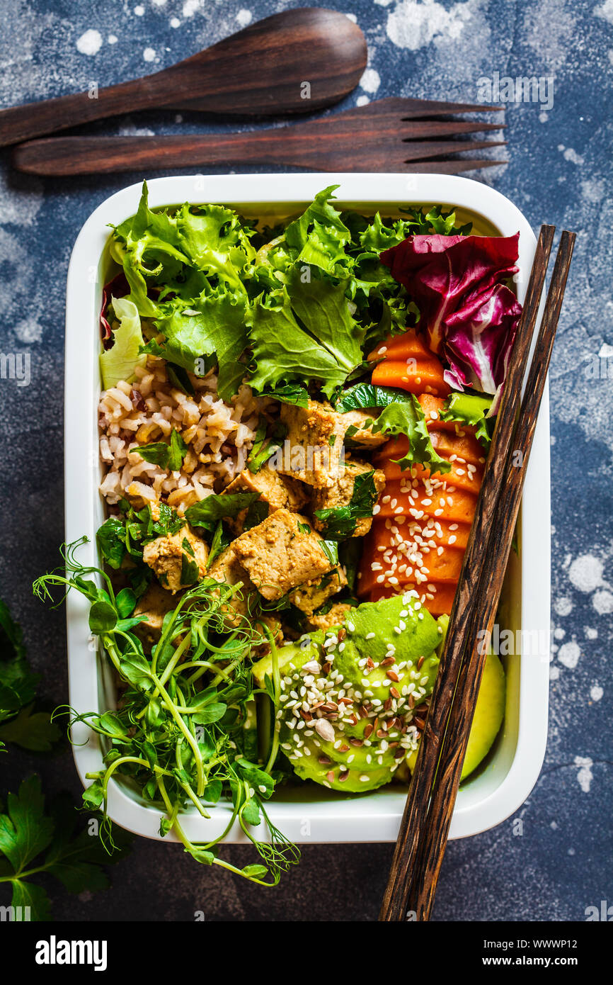 Lunch box with healthy vegan food. Bento box with rice, tofu and ...