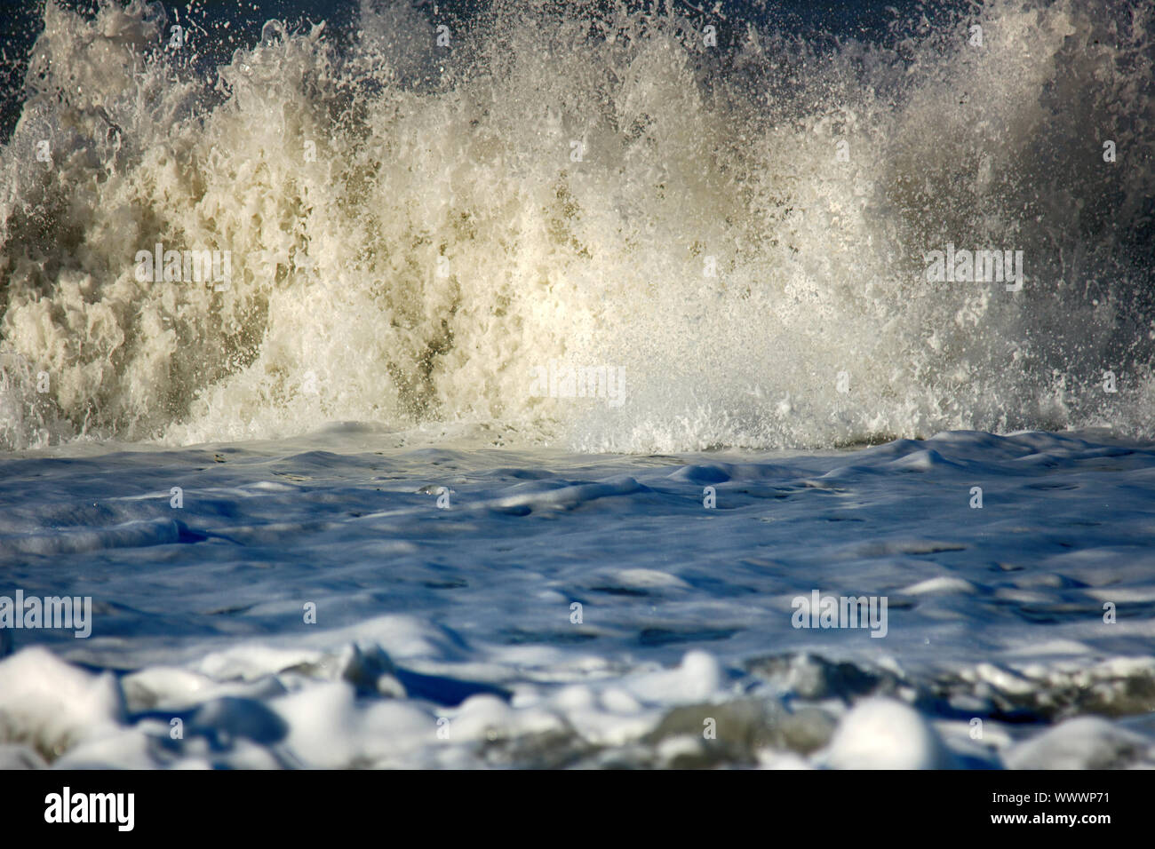 Sea rolling and receding water in rays of setting sun Stock Photo - Alamy