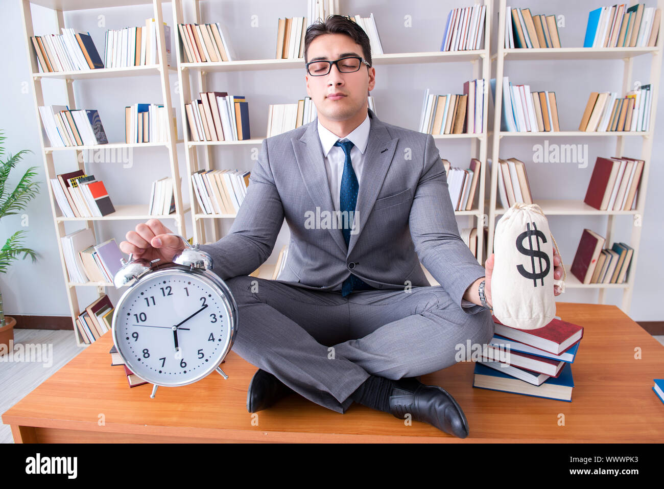 Businessman student in lotus position with an alarm clock and a Stock ...