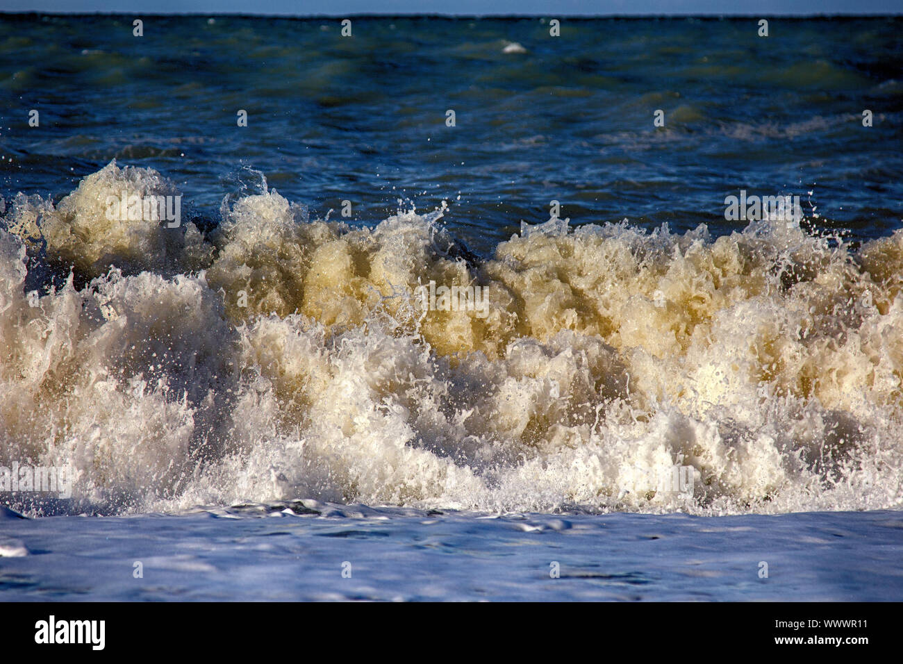 Sea rolling and receding water in rays of setting sun Stock Photo - Alamy