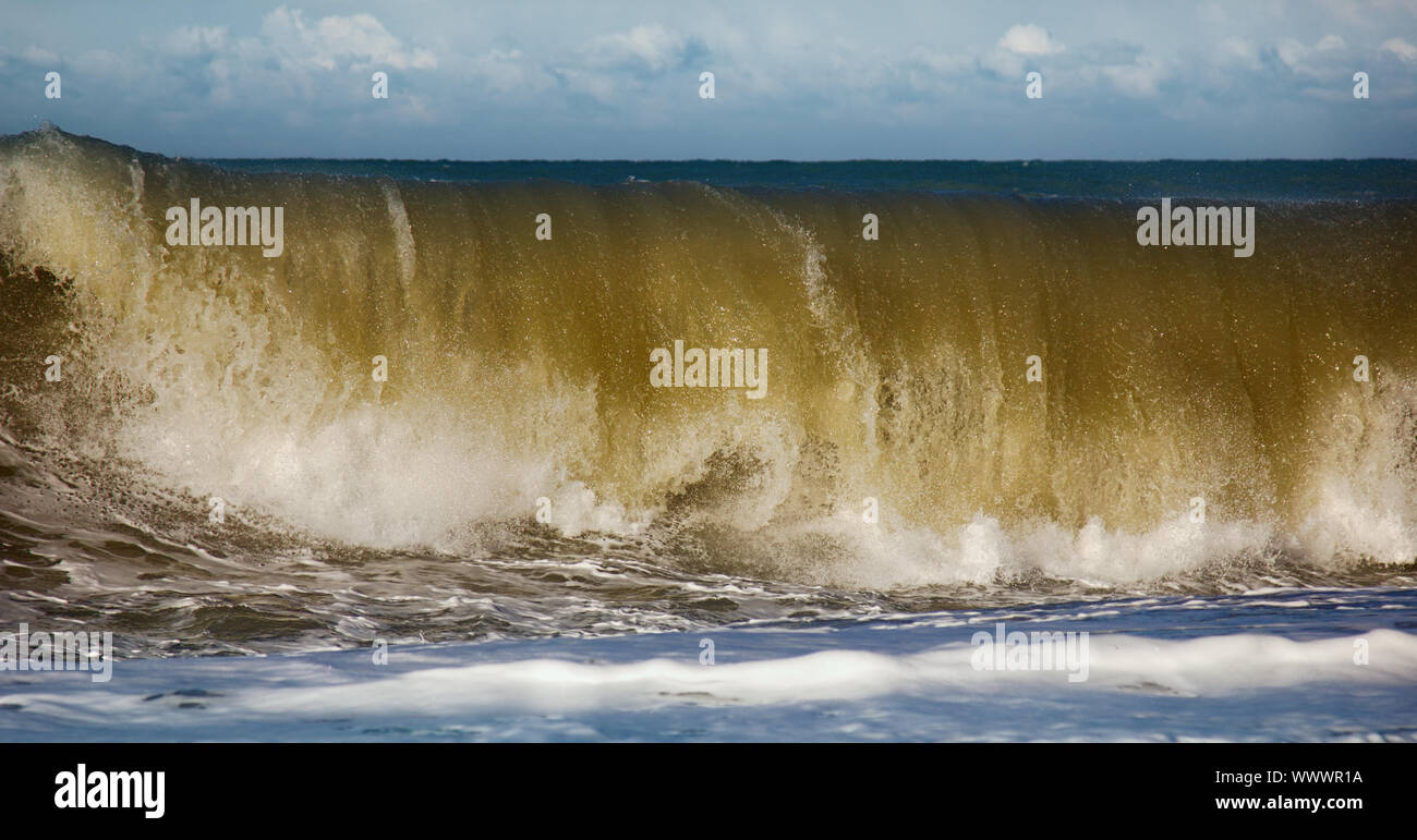 Sea rolling and receding water in rays of setting sun Stock Photo - Alamy