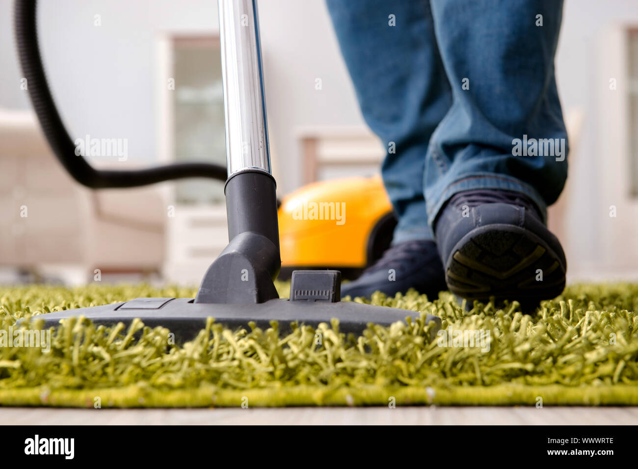 Man cleaning the floor carpet with a vacuum cleaner close up Stock ...