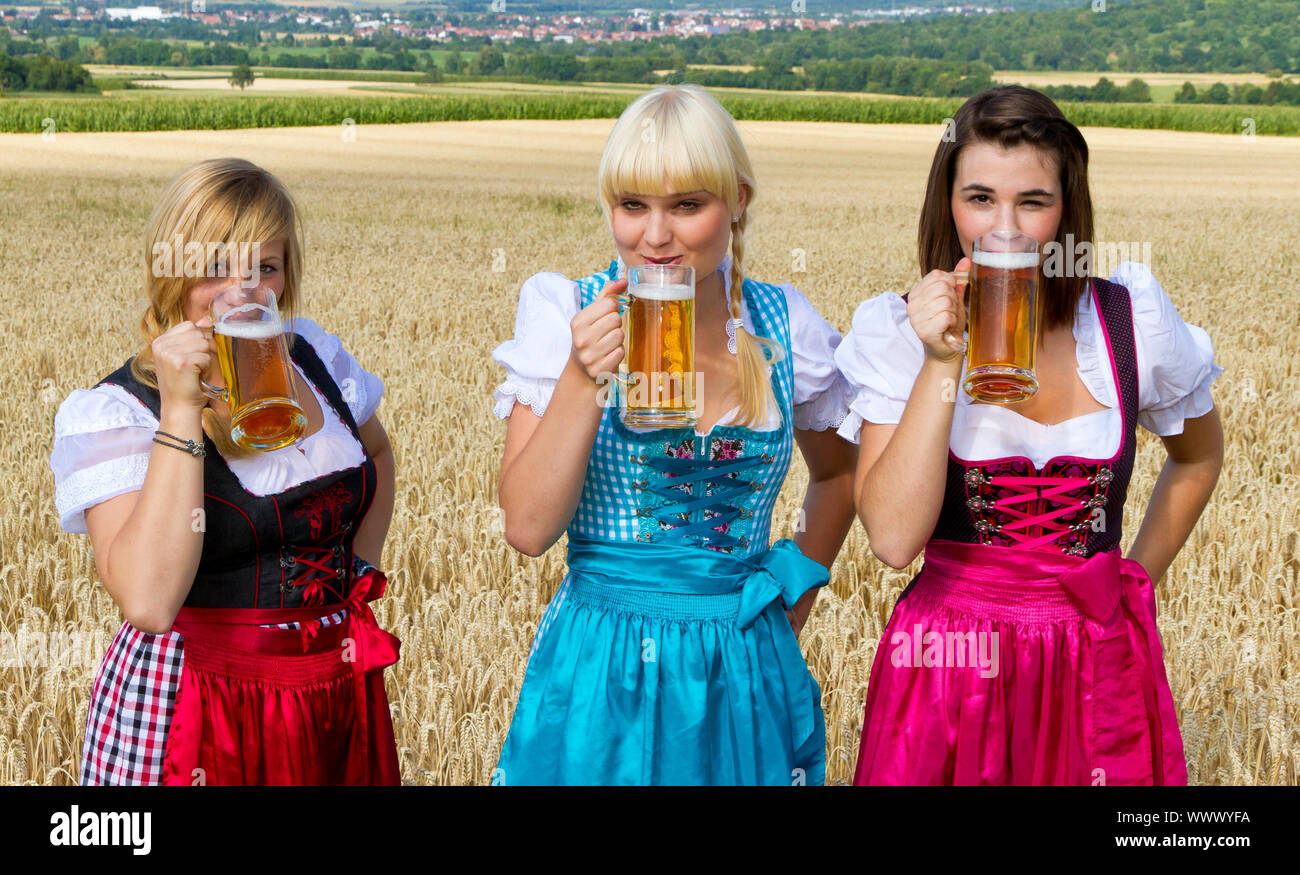 Girl in a traditional Dirndl drinking beer in the nature Stock Photo - Alamy