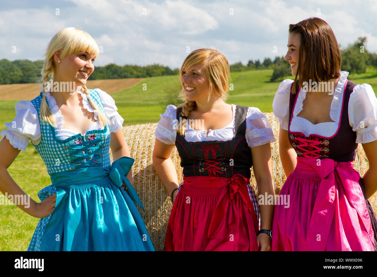 Three happy and cheerful girls in colorful dirndl Stock Photo - Alamy