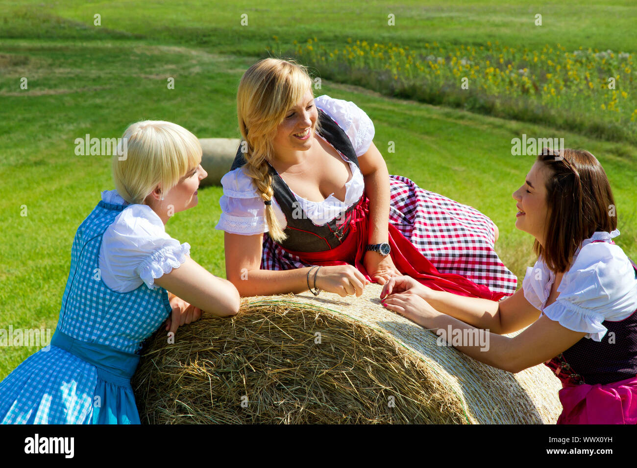 Three happy and cheerful girls in colorful dirndl Stock Photo - Alamy