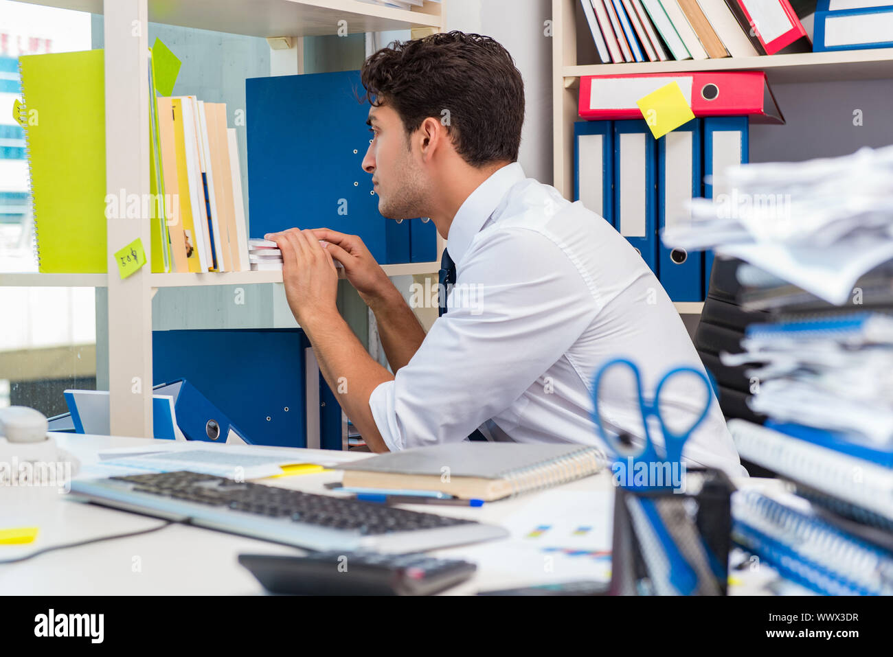 Businessman working in the office with piles of books and papers Stock ...