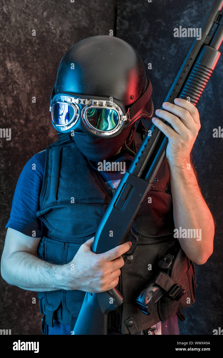 man armed with balaclava and bulletproof vest, gun and shotgun ...