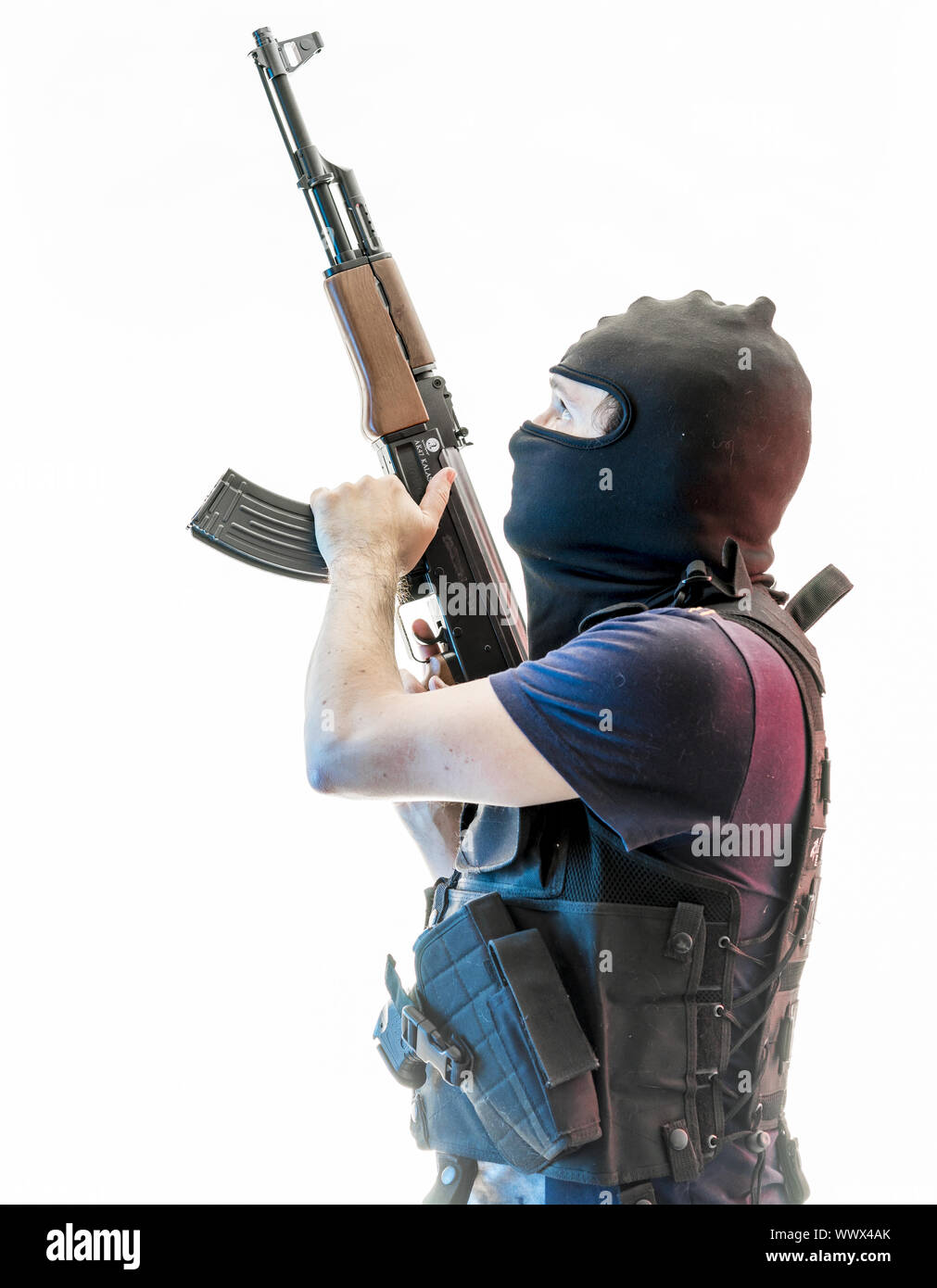 Criminal man armed with balaclava and bulletproof vest, gun and shotgun ...