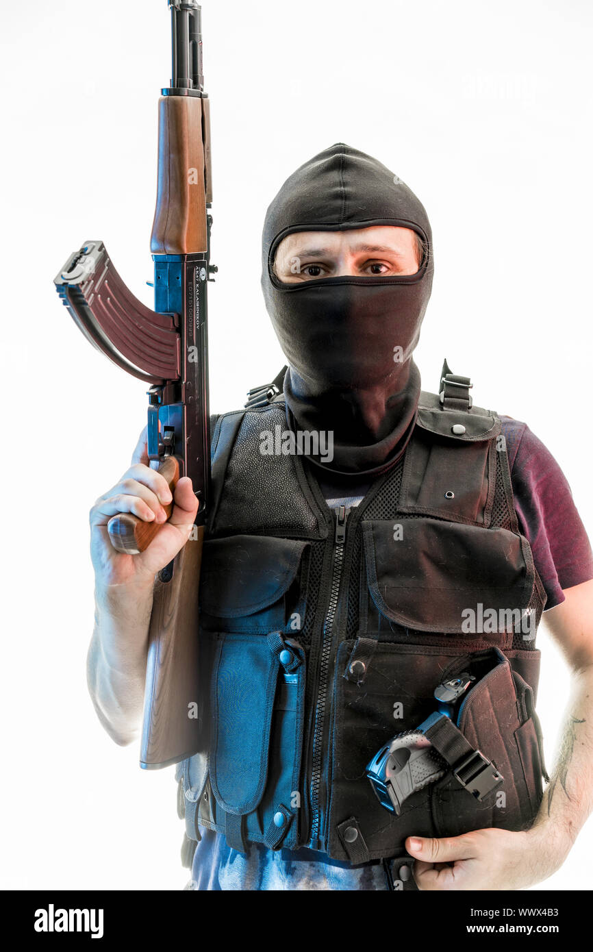 Criminal man armed with balaclava and bulletproof vest, gun and shotgun ...