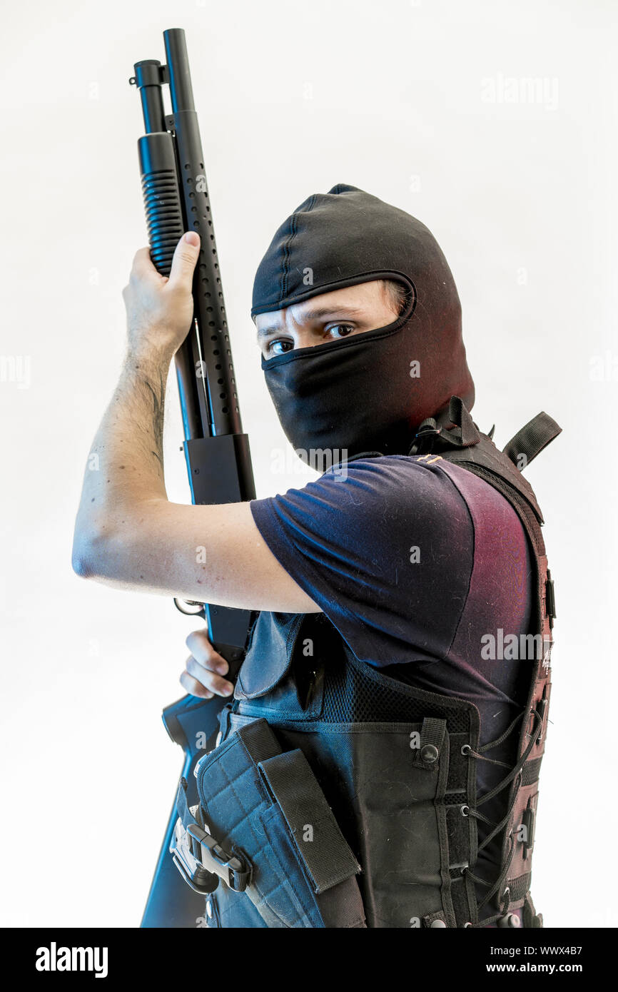 man armed with balaclava and bulletproof vest, gun and shotgun ...