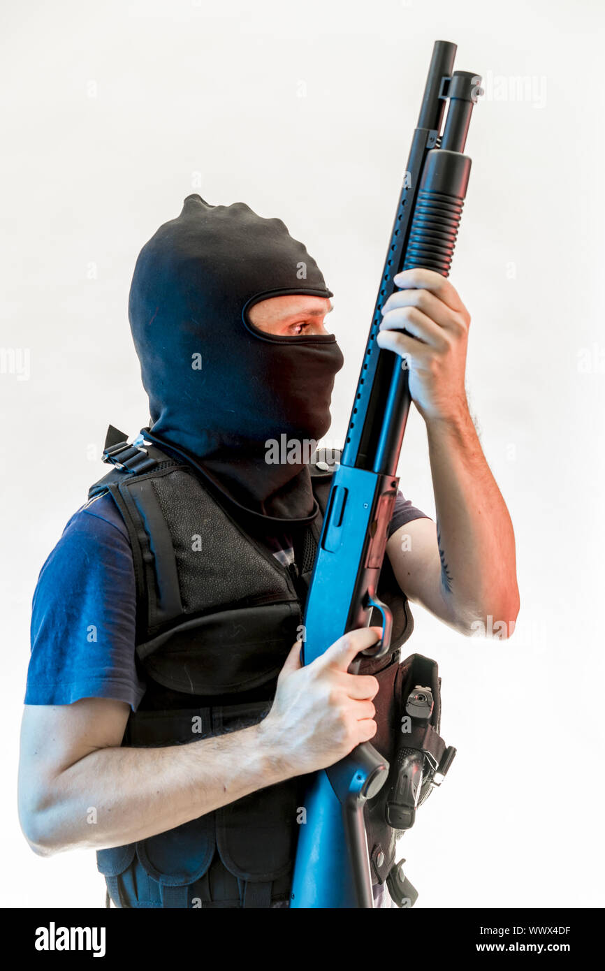 man armed with balaclava and bulletproof vest, gun and shotgun ...