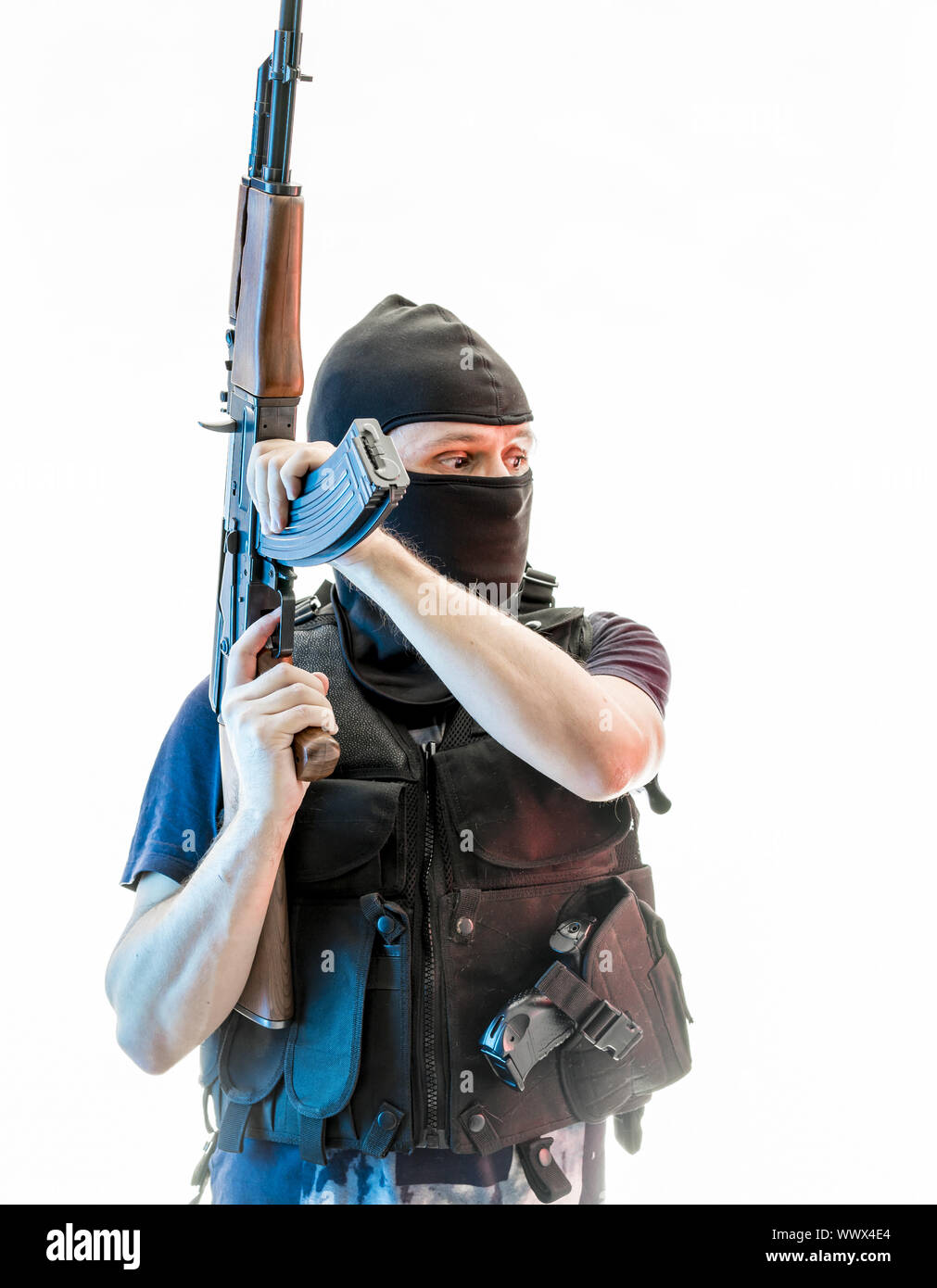 Criminal man armed with balaclava and bulletproof vest, gun and shotgun ...
