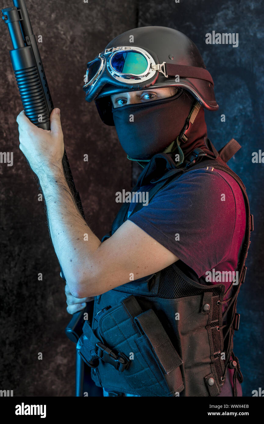 man armed with balaclava and bulletproof vest, gun and shotgun ...