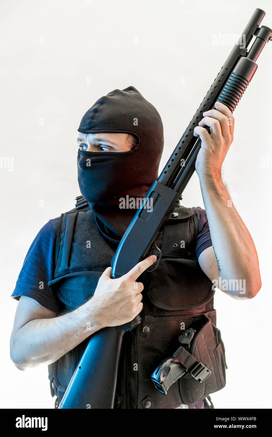 man armed with balaclava and bulletproof vest, gun and shotgun ...