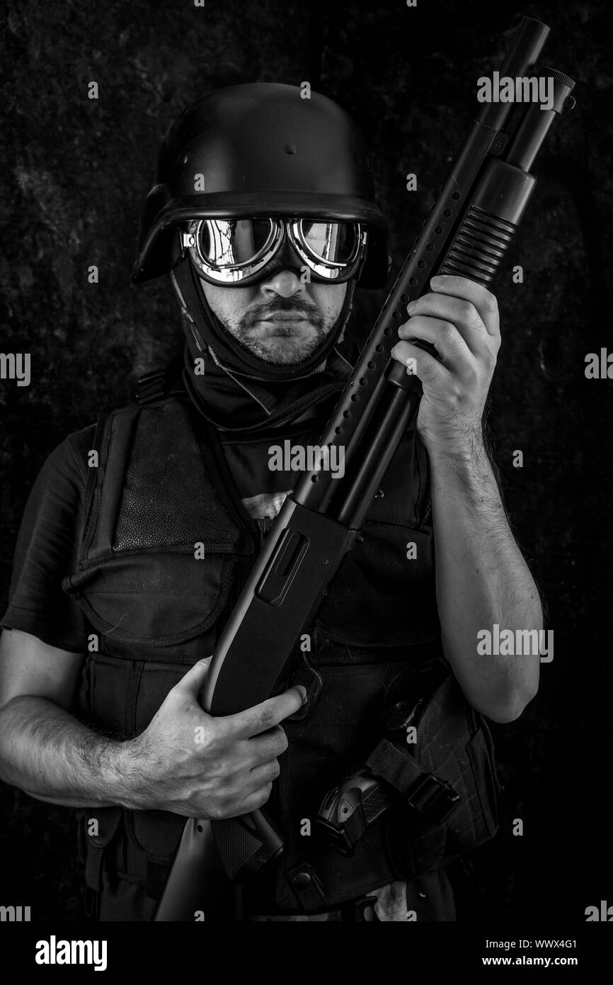 man armed with balaclava and bulletproof vest, gun and shotgun ...