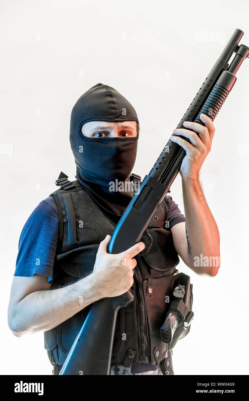 man armed with balaclava and bulletproof vest, gun and shotgun ...