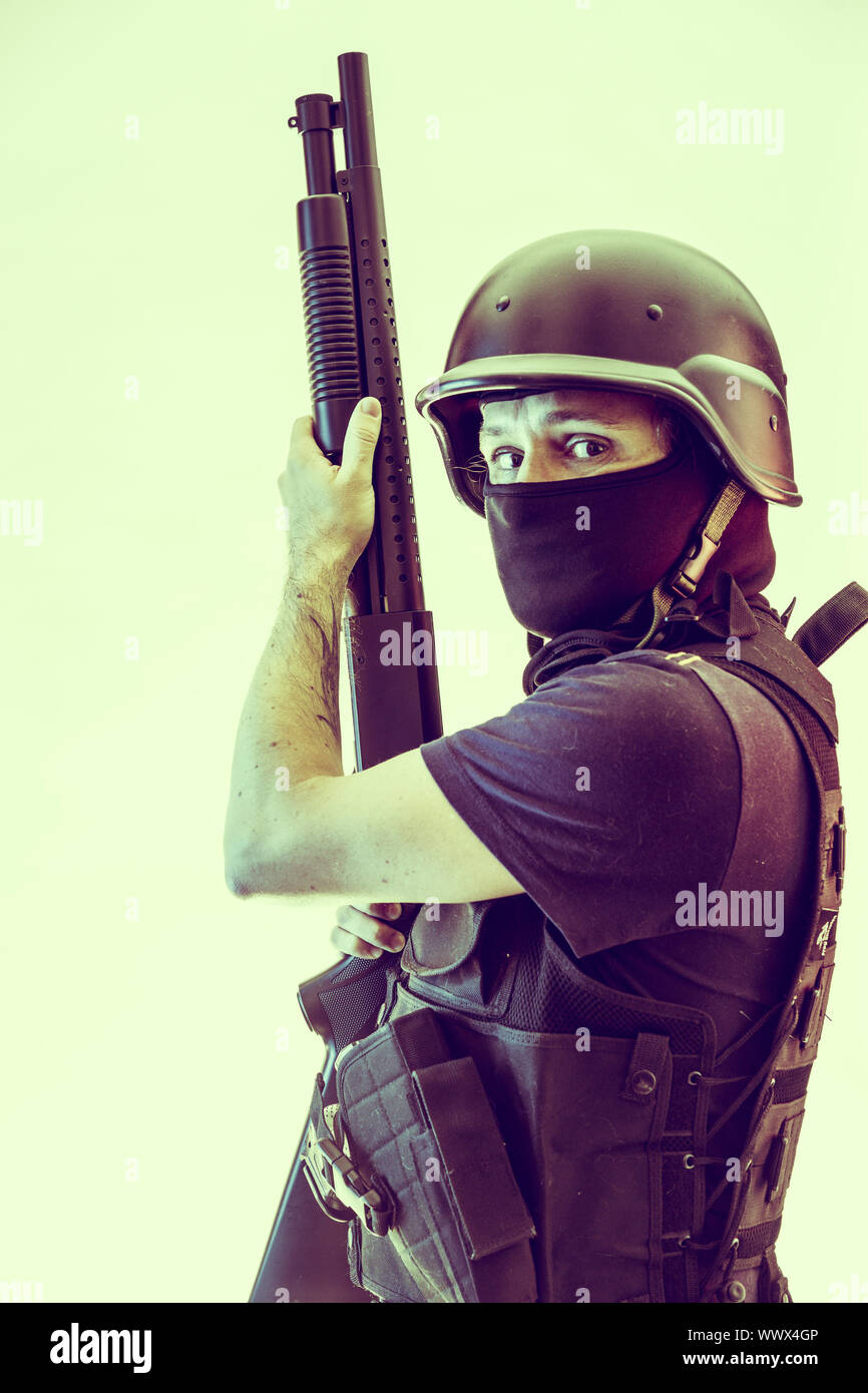 Thief, man armed with balaclava and bulletproof vest, gun and shotgun ...