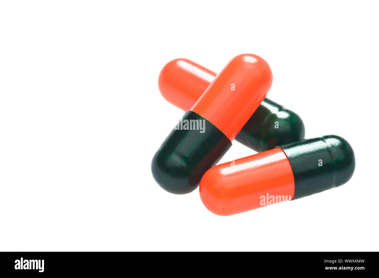 Three red black capsules over white Stock Photo - Alamy