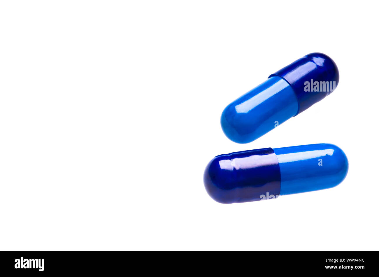 Two bicolor capsules over white Stock Photo - Alamy