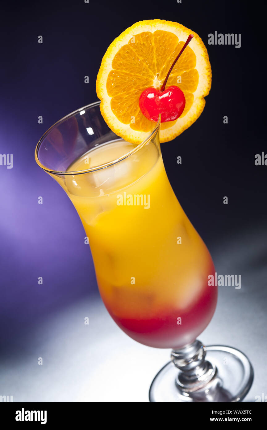 Tequila sunrise Cocktail in front of different colored backgrounds ...