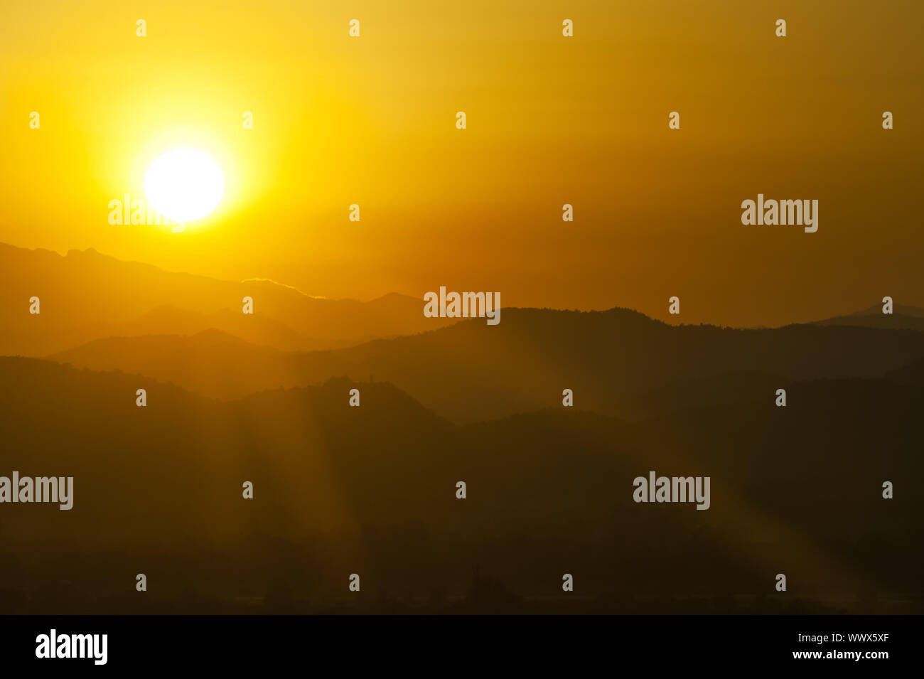 Sunset behind mountains Stock Photo - Alamy