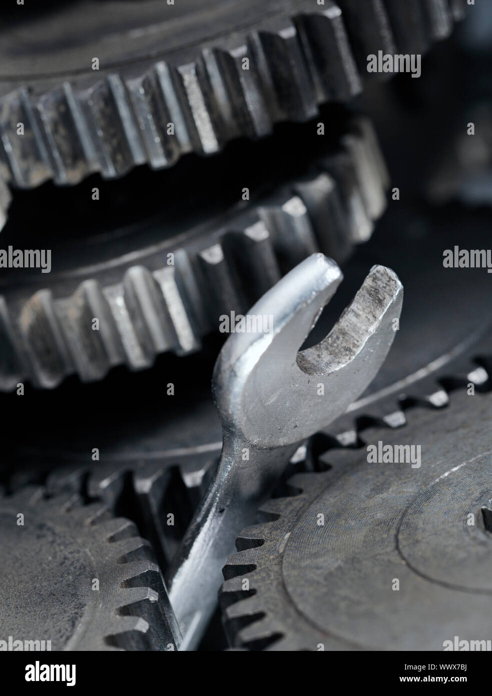 A Spanner Wrench stuck between cog gear wheels Stock Photo - Alamy