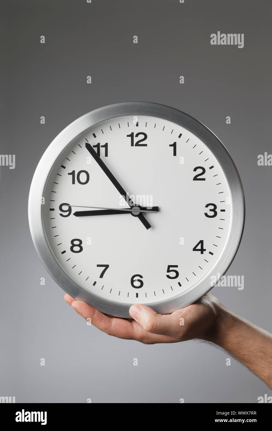 Man holding a clock in his hand Stock Photo - Alamy