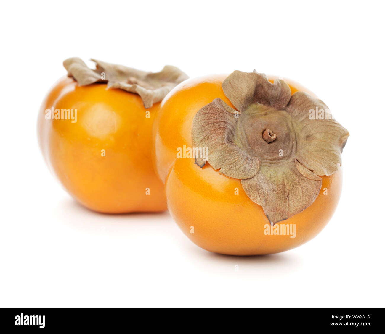 Two persimmon sharon fruits isolated on white with natural shadows ...